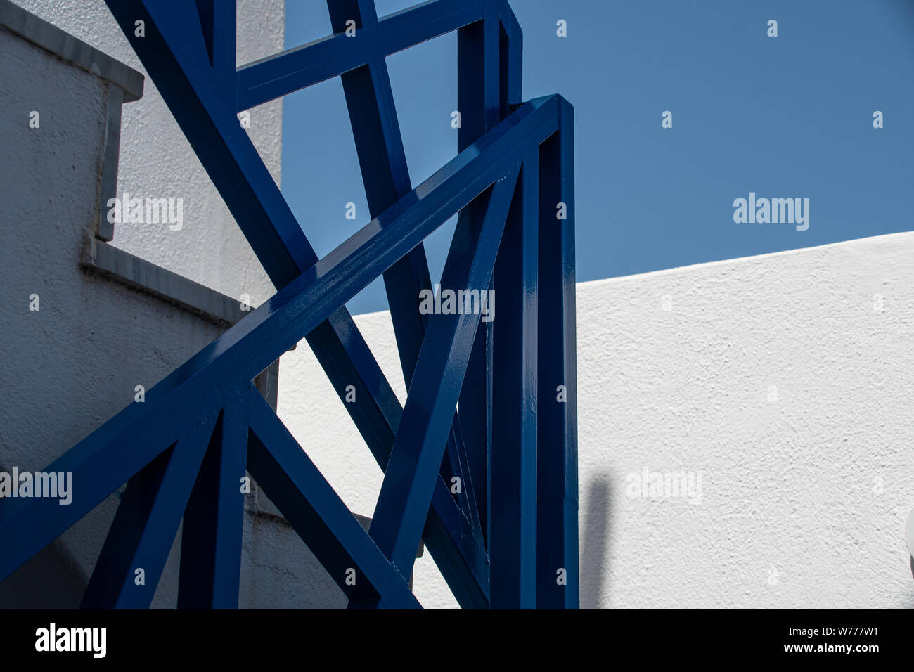 A Blue metal bannister along a whitewashed stair case Stock Photo - Alamy