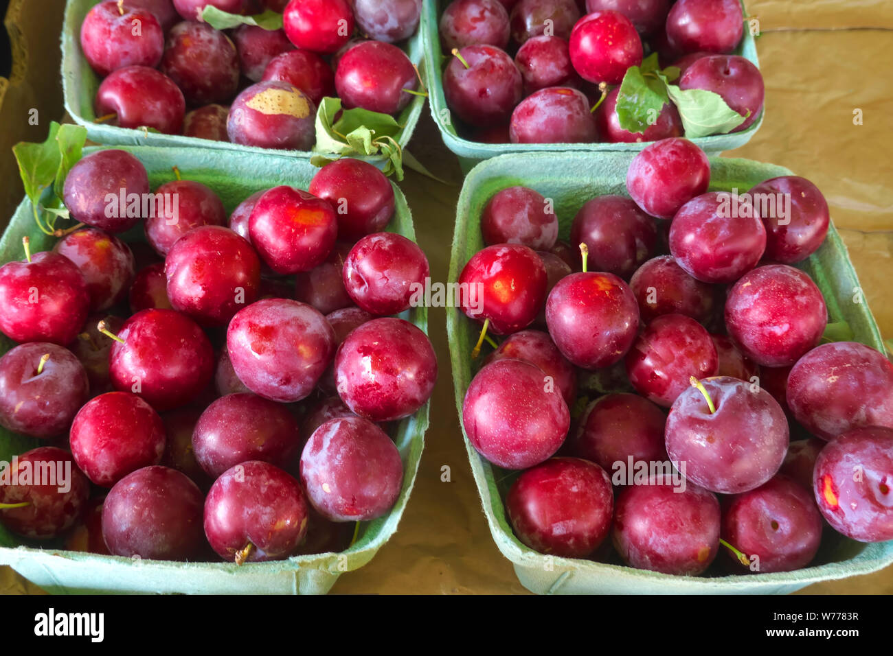 Baskets of red plums on display at an outdoor market Stock Photo - Alamy