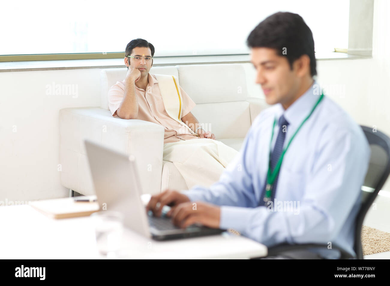 Indian financial advisor working on a laptop with a South Indian man ...
