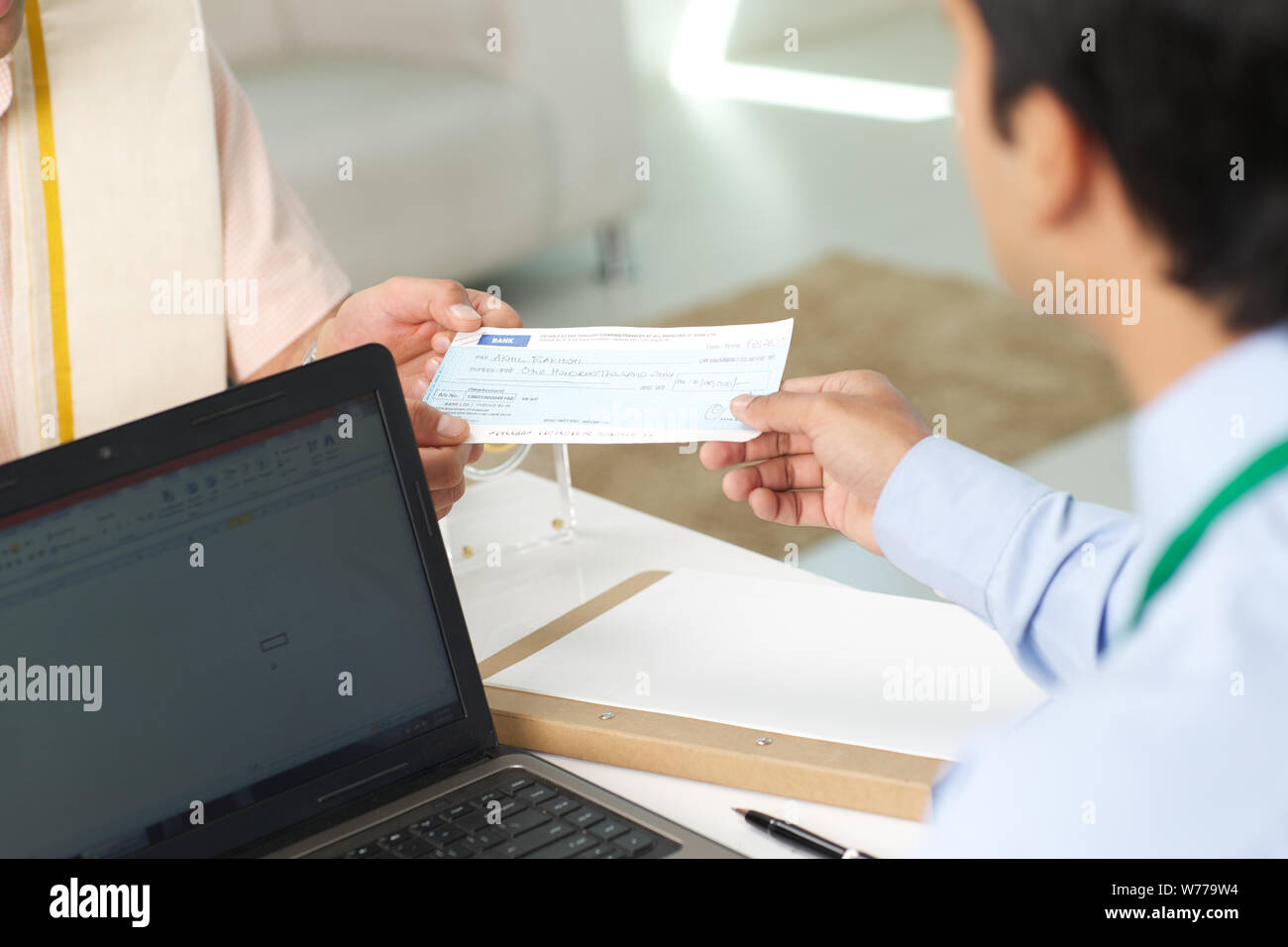 Bank manager giving cheque to his customer as loan Stock Photo - Alamy