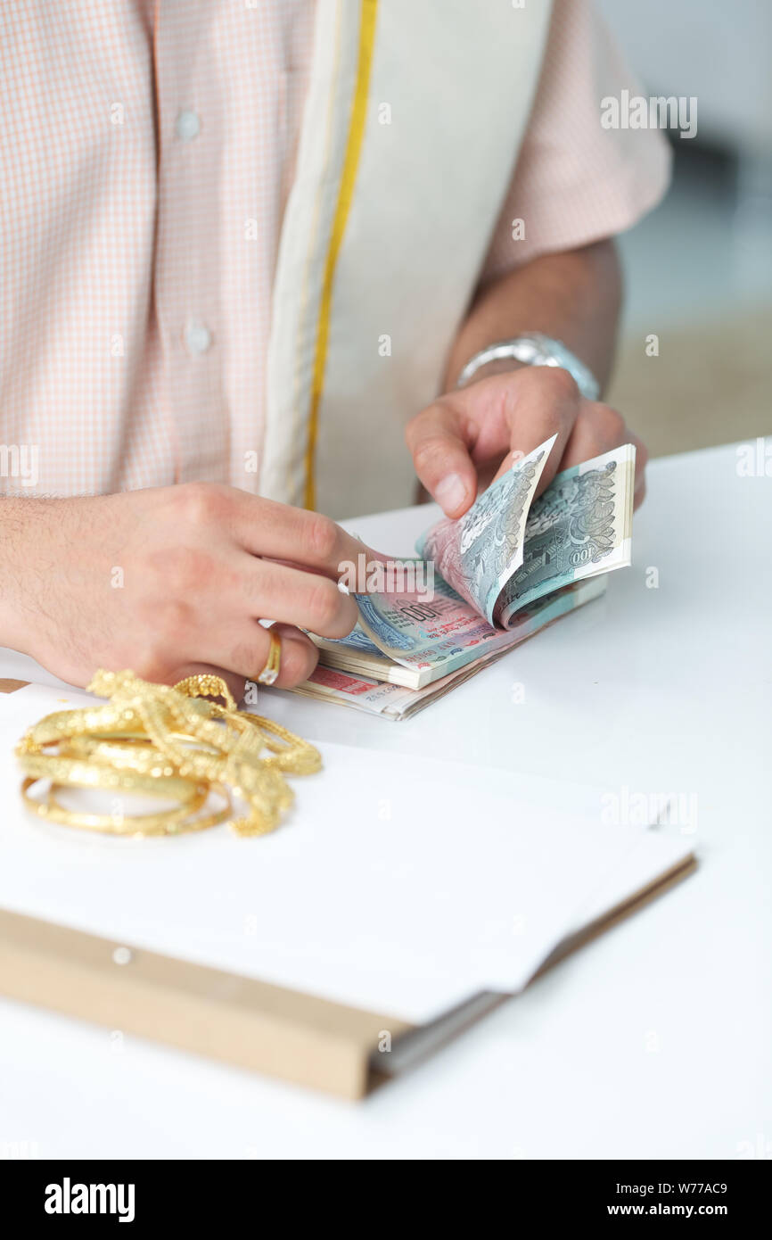 South Indian man counting money of gold loan Stock Photo - Alamy