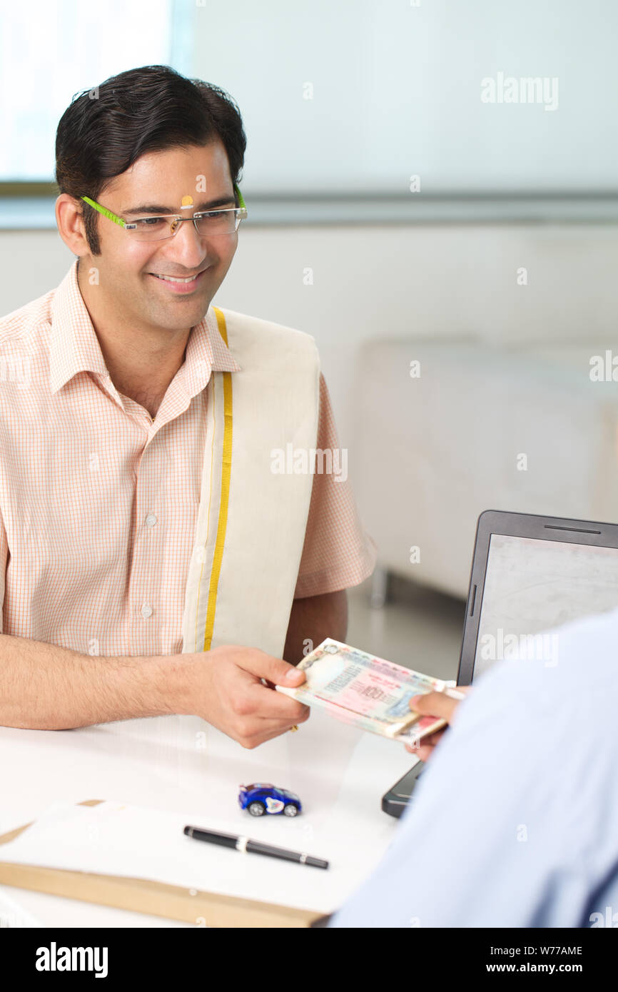 South Indian man taking cash from bank manager as loan Stock Photo - Alamy