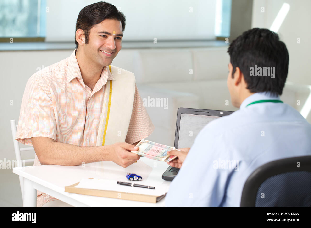 South Indian man taking cash from bank manager as loan Stock Photo - Alamy