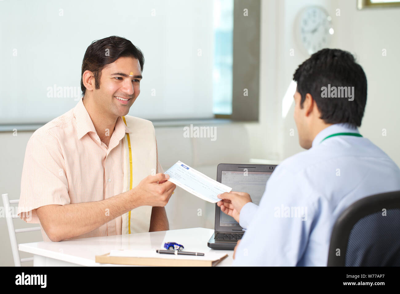 South Indian man taking cheque from bank manager as loan Stock Photo ...