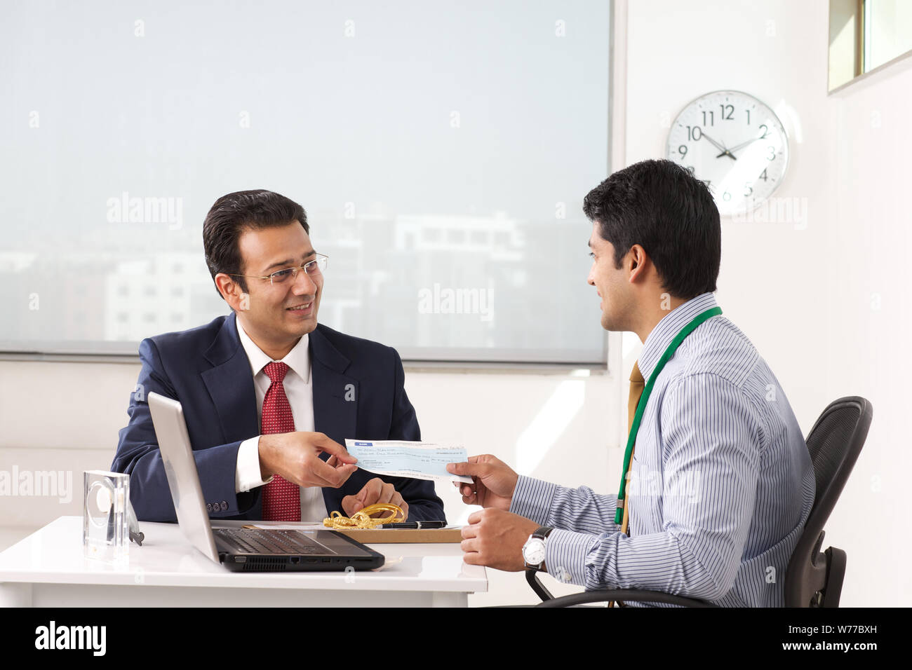Bank manager giving cheque to his customer as loan Stock Photo - Alamy