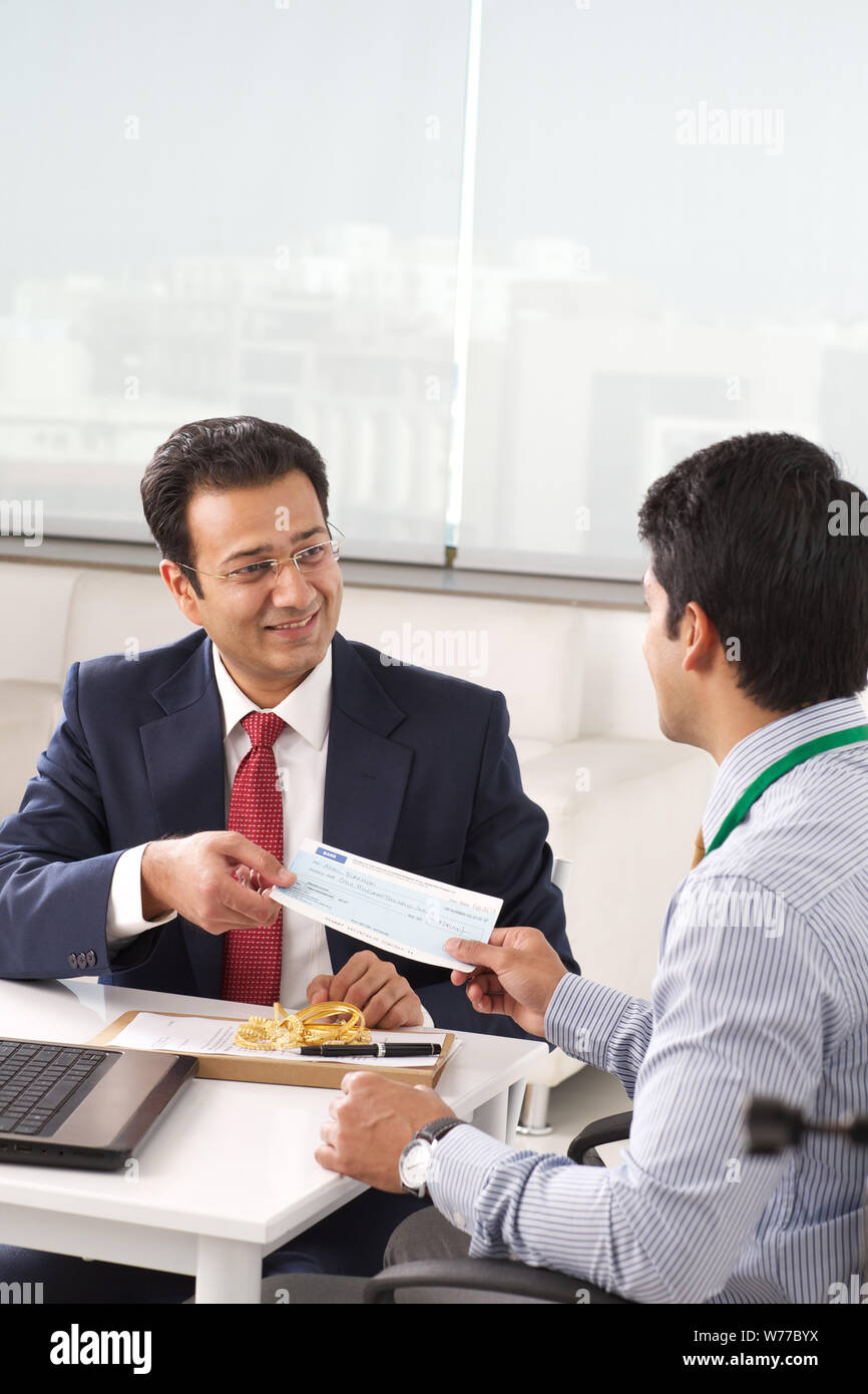 Bank manager giving cheque to his customer as loan Stock Photo - Alamy