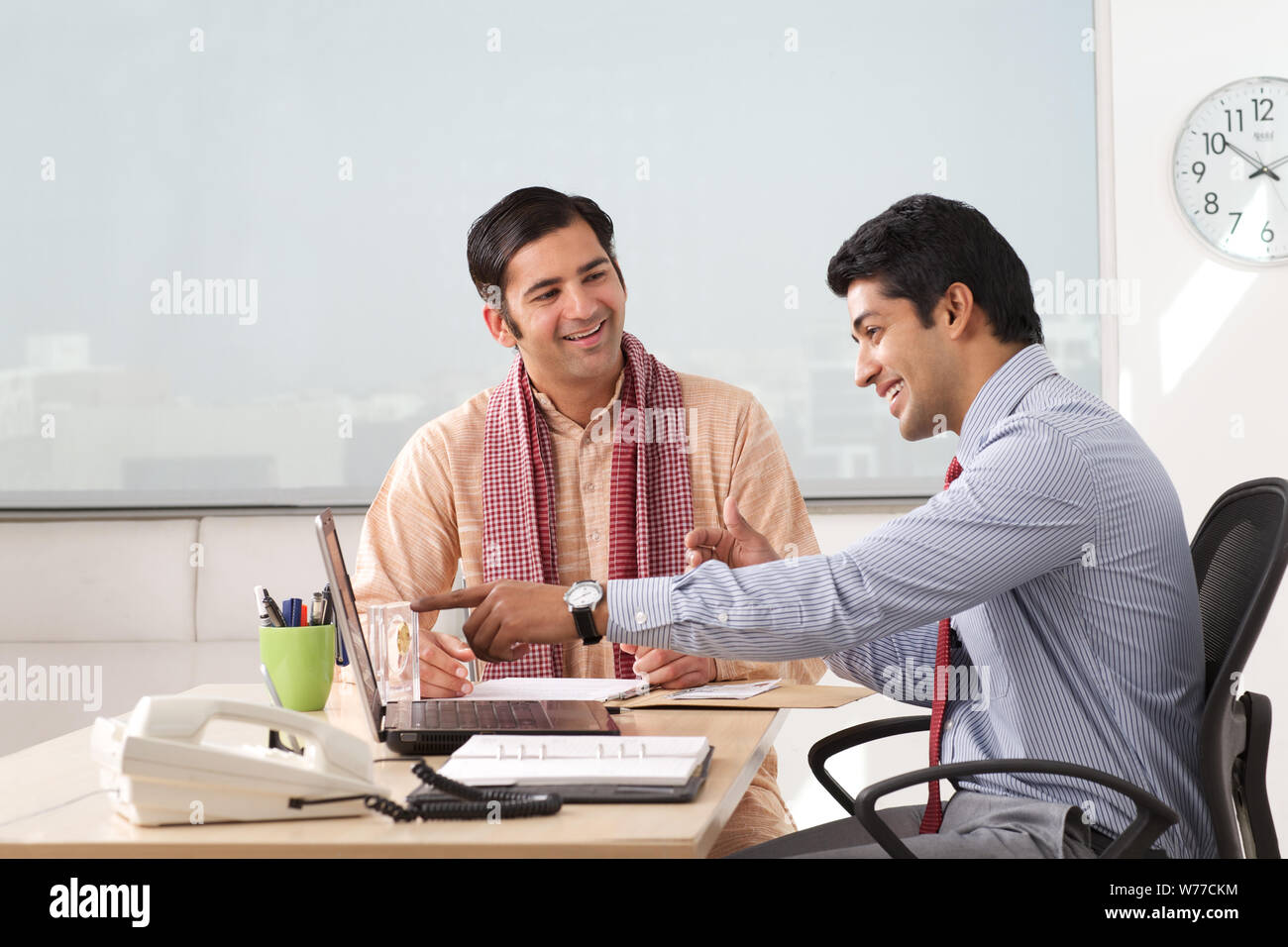 Bank manager showing a laptop to his customer Stock Photo - Alamy
