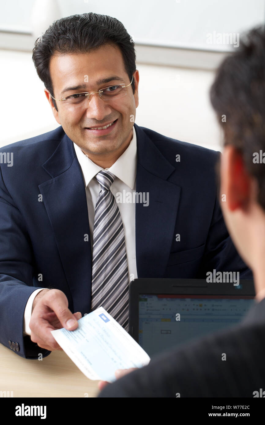Bank manager giving cheque to his customer as loan Stock Photo - Alamy
