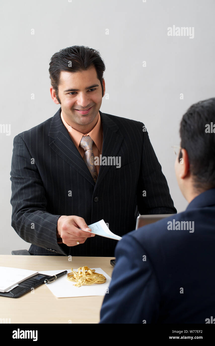 Bank teller giving cheque to his customer as loan Stock Photo - Alamy