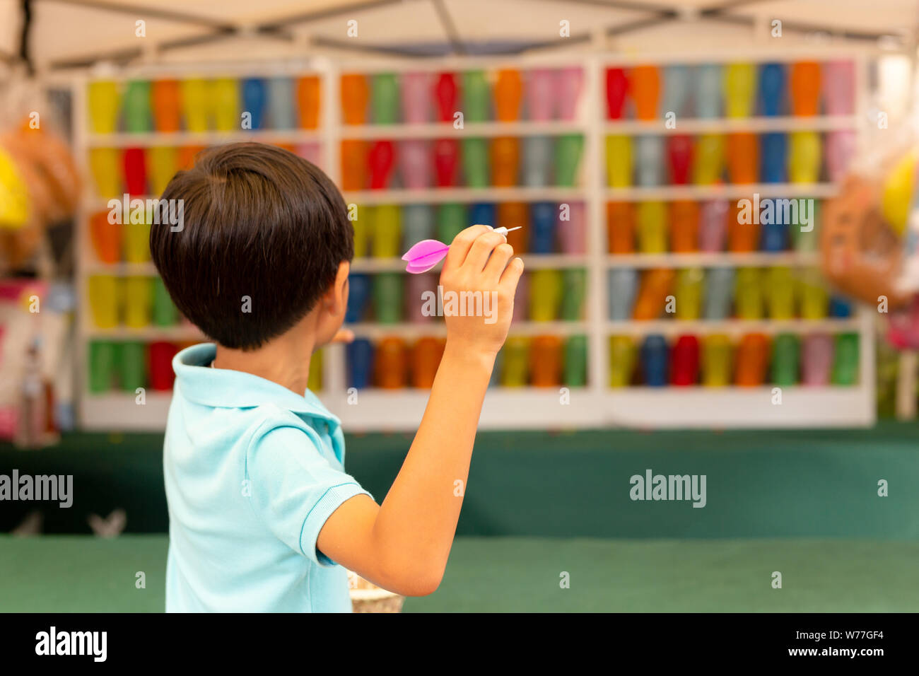 Boy playing the dart game with multicolor balloons at fair Stock Photo ...