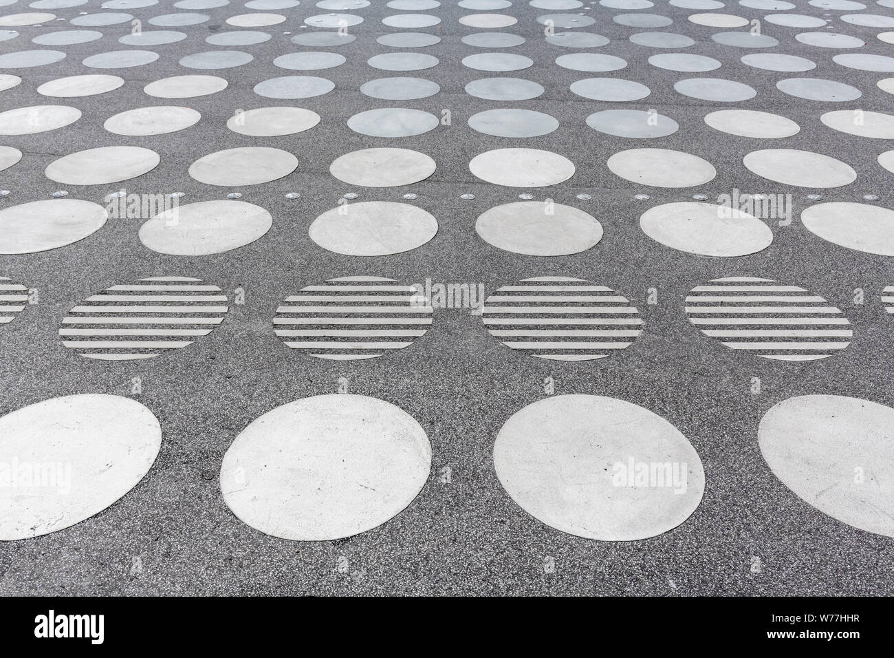 A concrete square with a symmetrical white circle pattern seen in ...