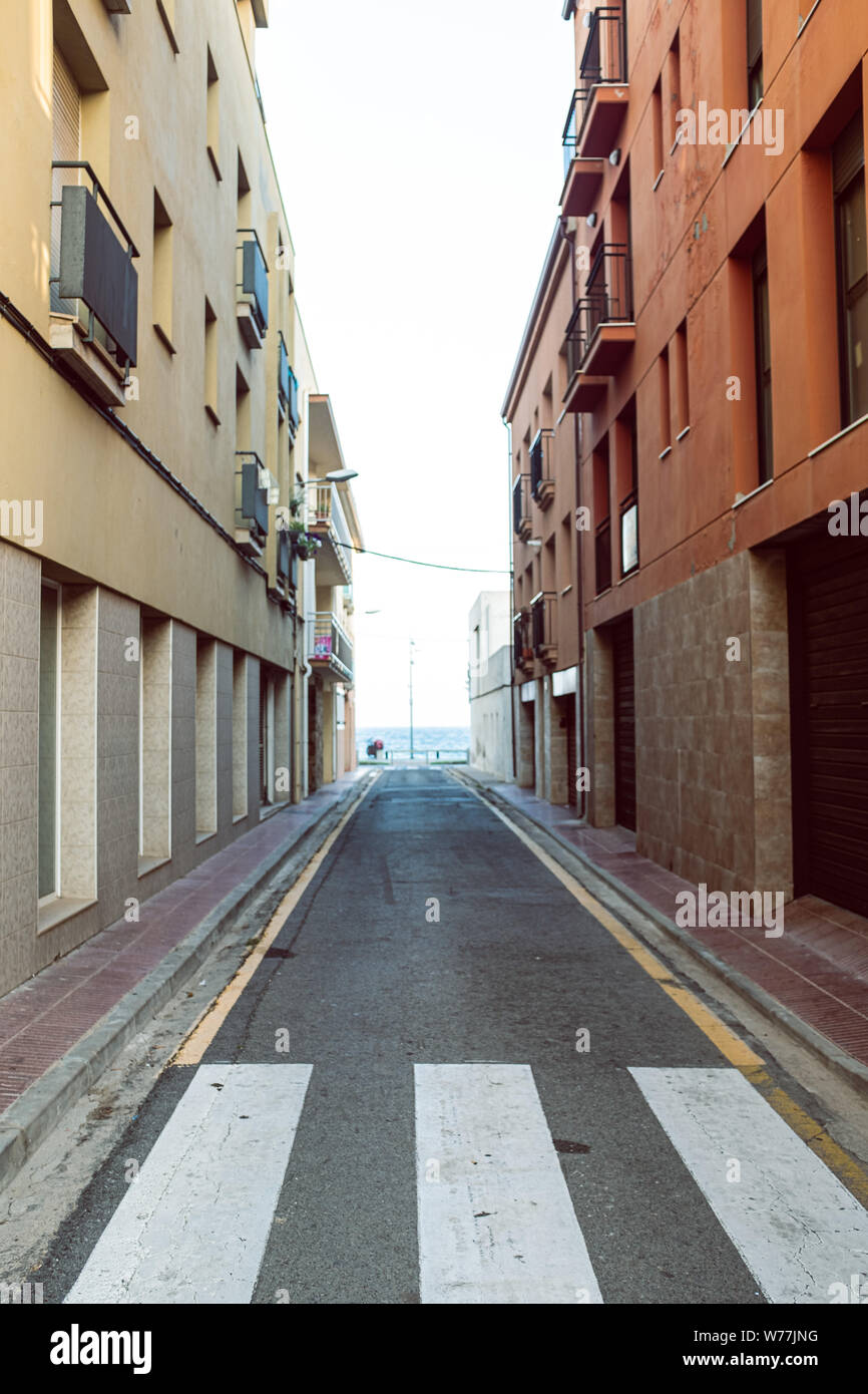 Narrow street with zebra pedestrian walkway Stock Photo - Alamy