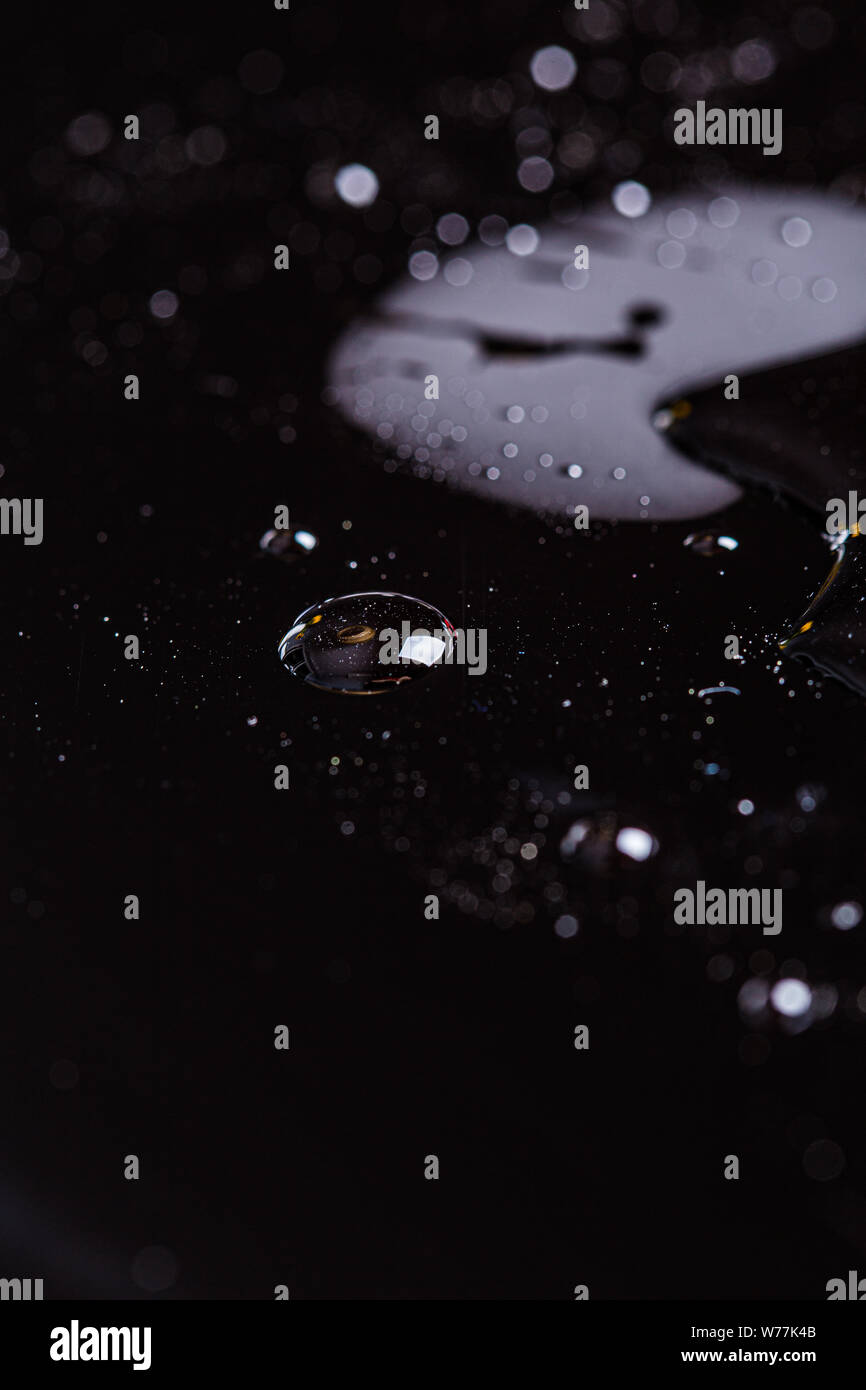 Water drops on a reflective black surface Stock Photo - Alamy