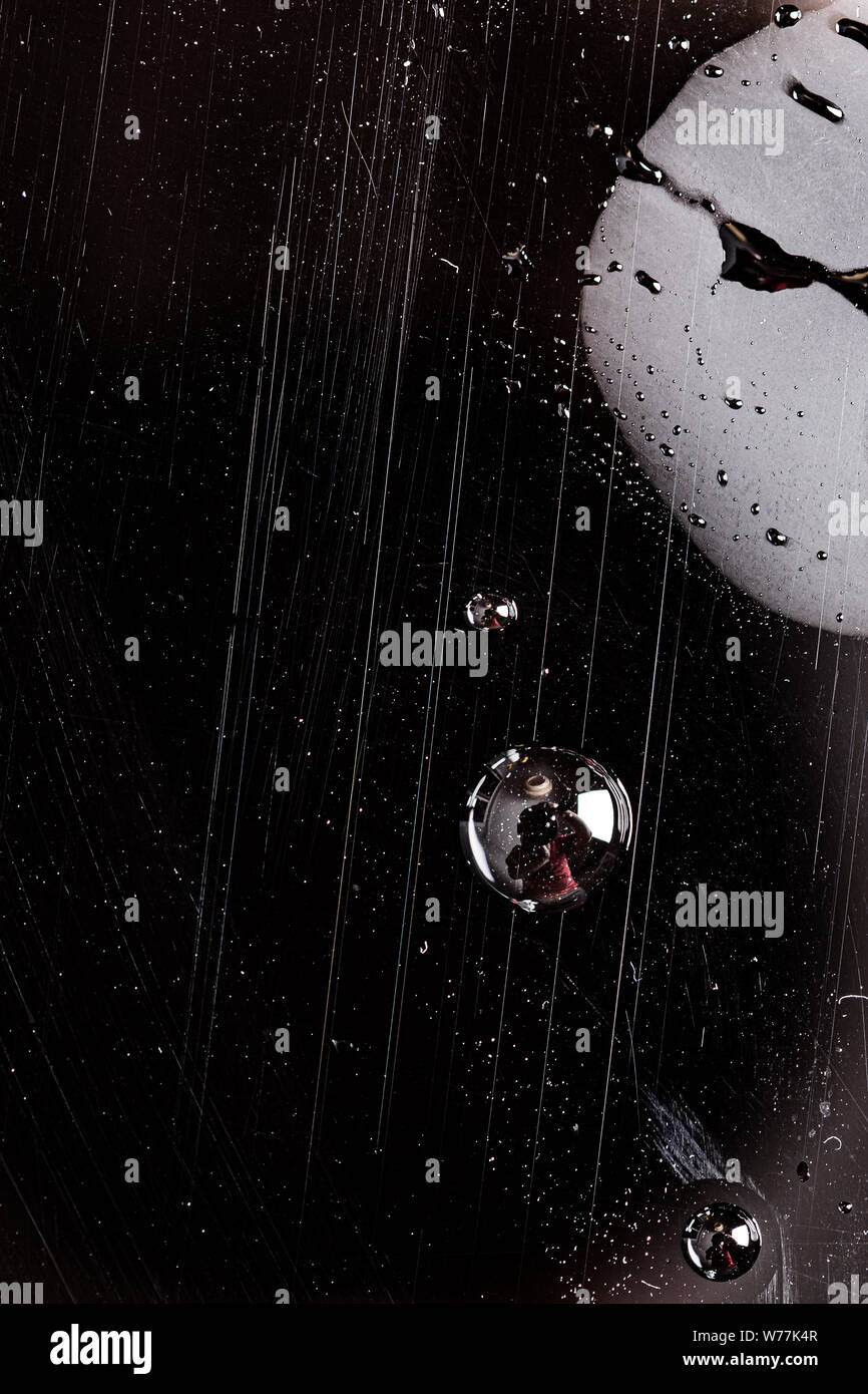 Water drops on a reflective black surface Stock Photo - Alamy