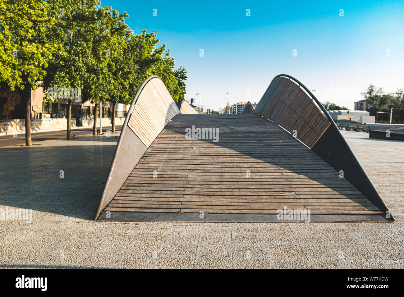 Modern bridge building on a urban park in Girona on a solid blue sky ...