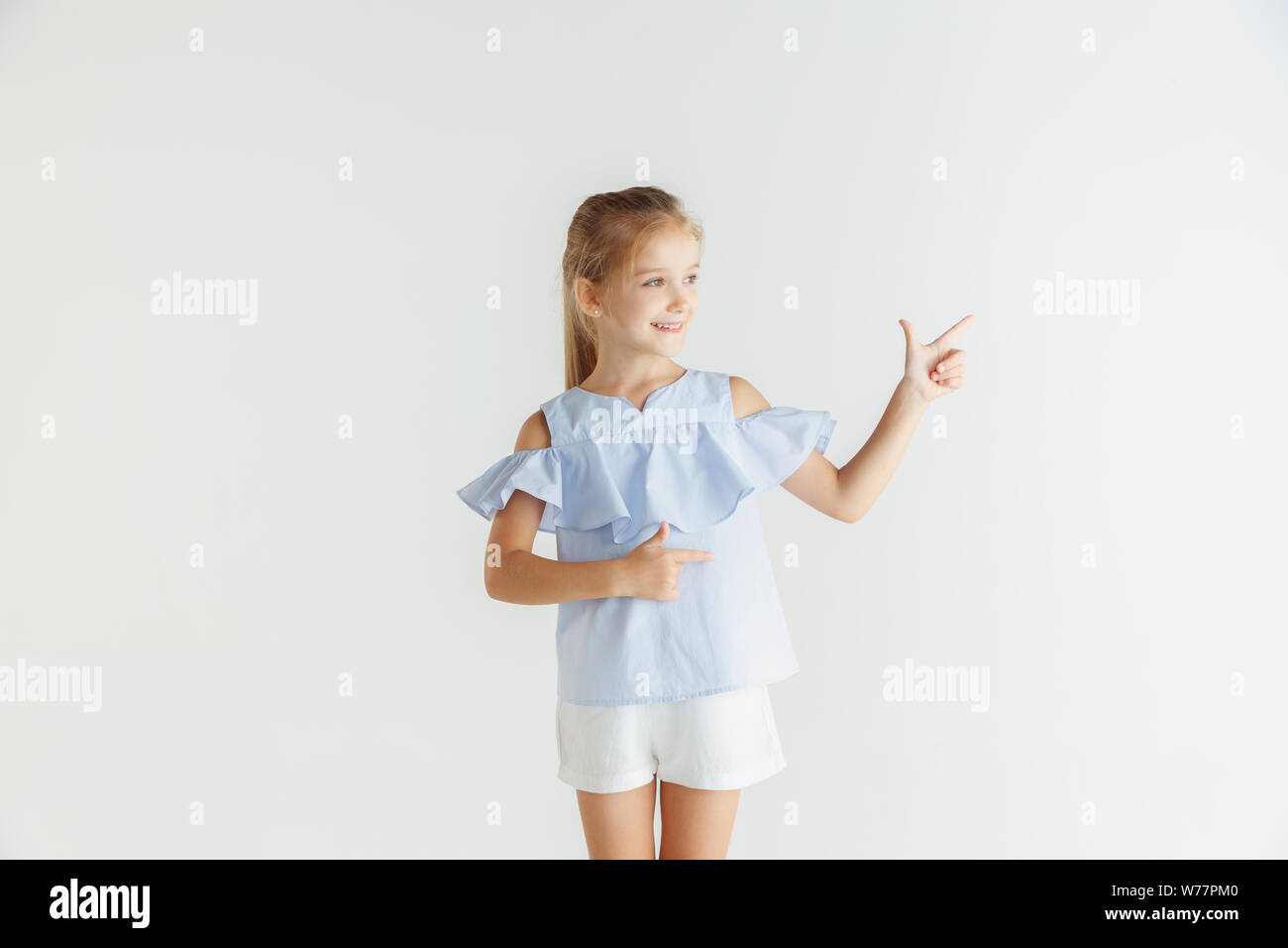 Stylish little smiling girl posing in casual clothes isolated on white ...