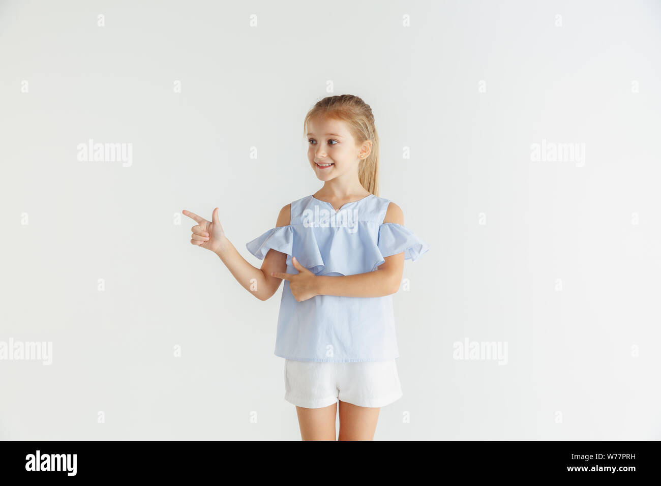 Stylish little smiling girl posing in casual clothes isolated on white ...