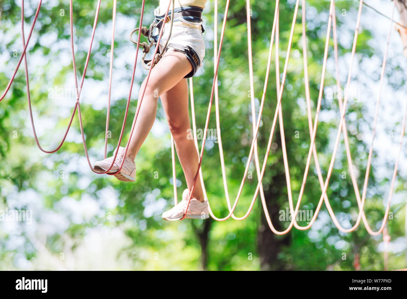 Rope Park. Foot on the rope. Man spend their leisure time in a ropes ...