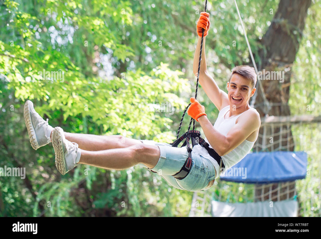 Man spend their leisure time in a ropes course. Man engaged in rope ...