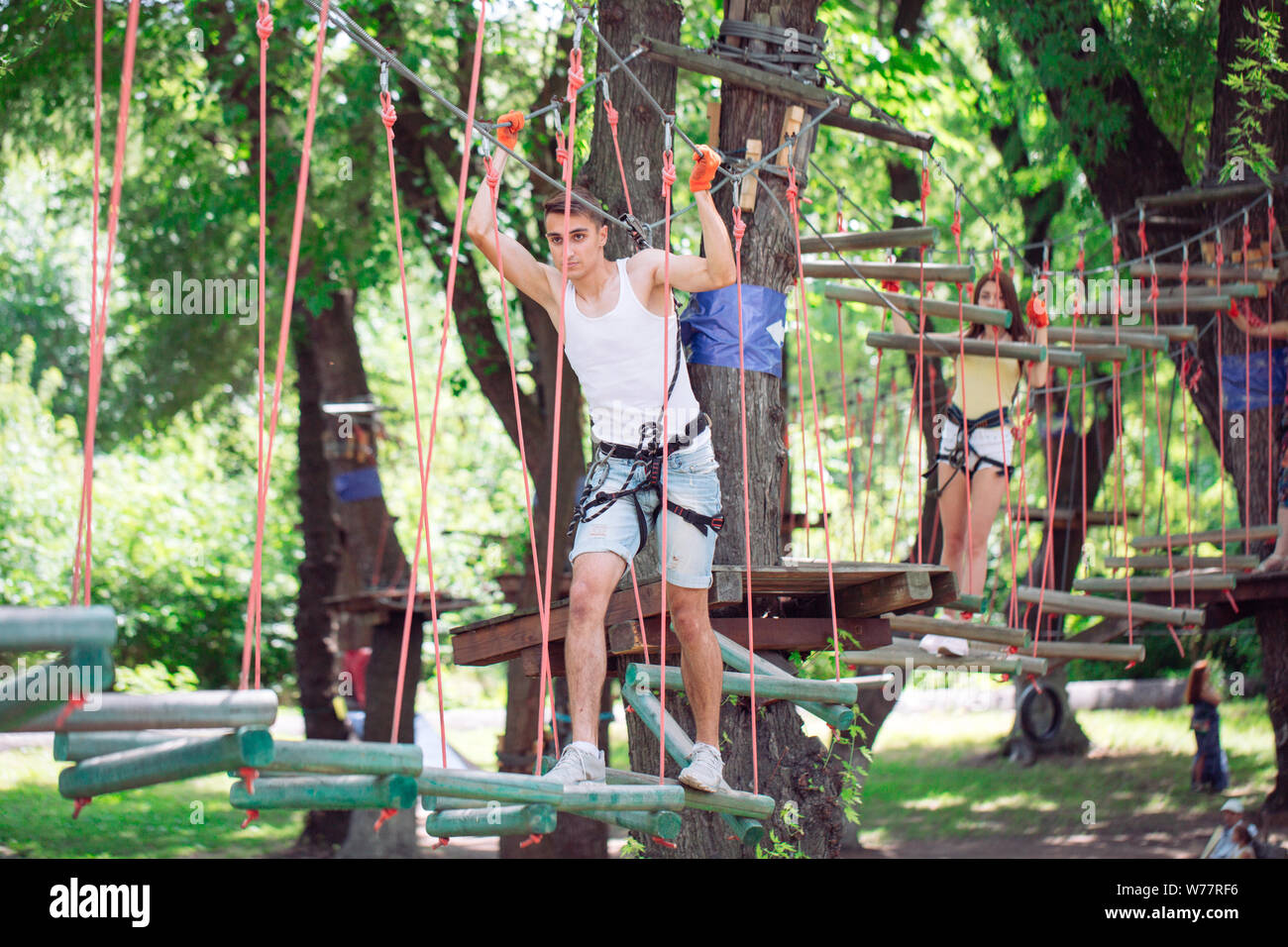Man spend their leisure time in a ropes course. Man engaged in rope ...