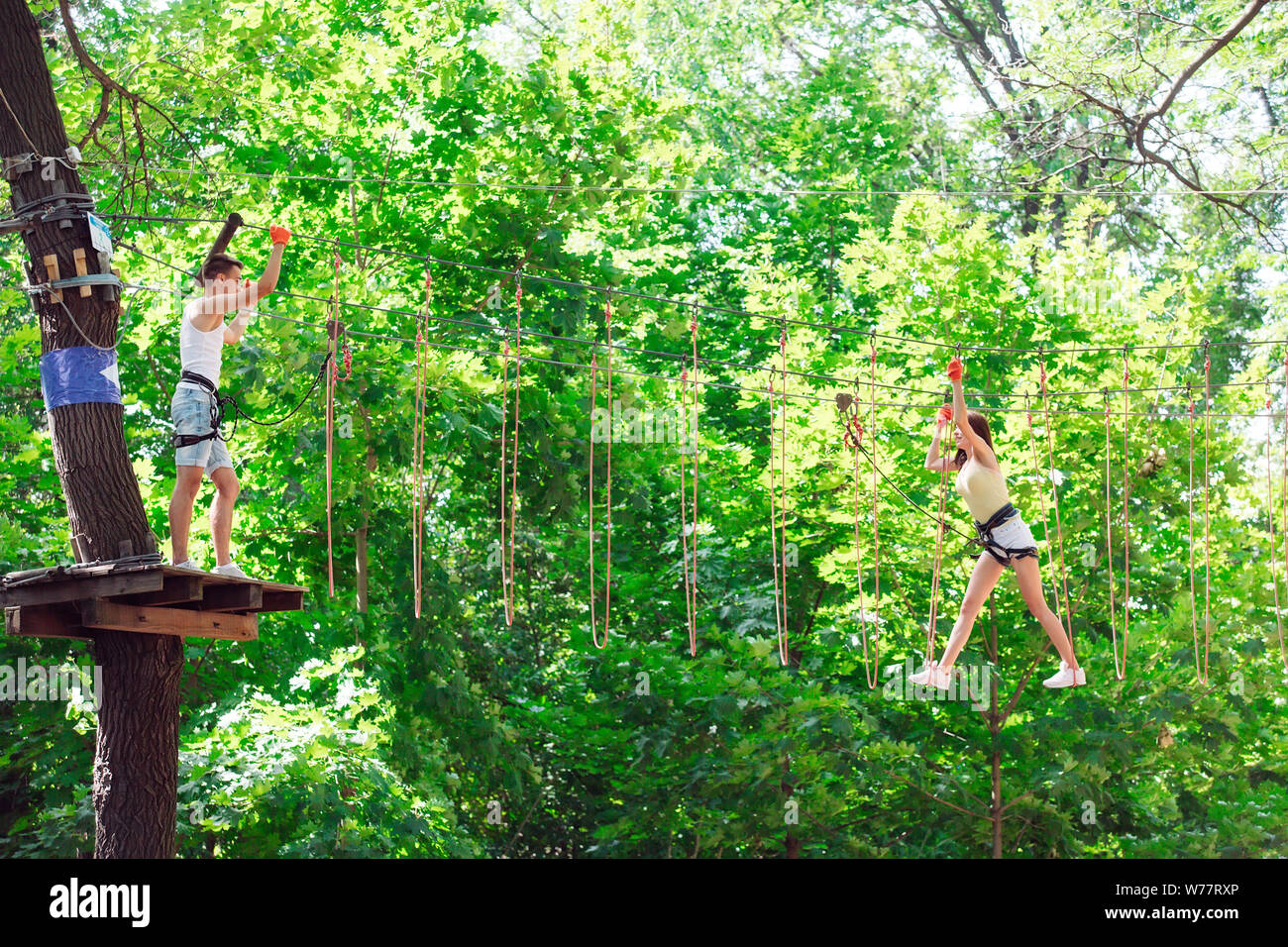 couple spend their leisure time in a ropes course. man and woman ...