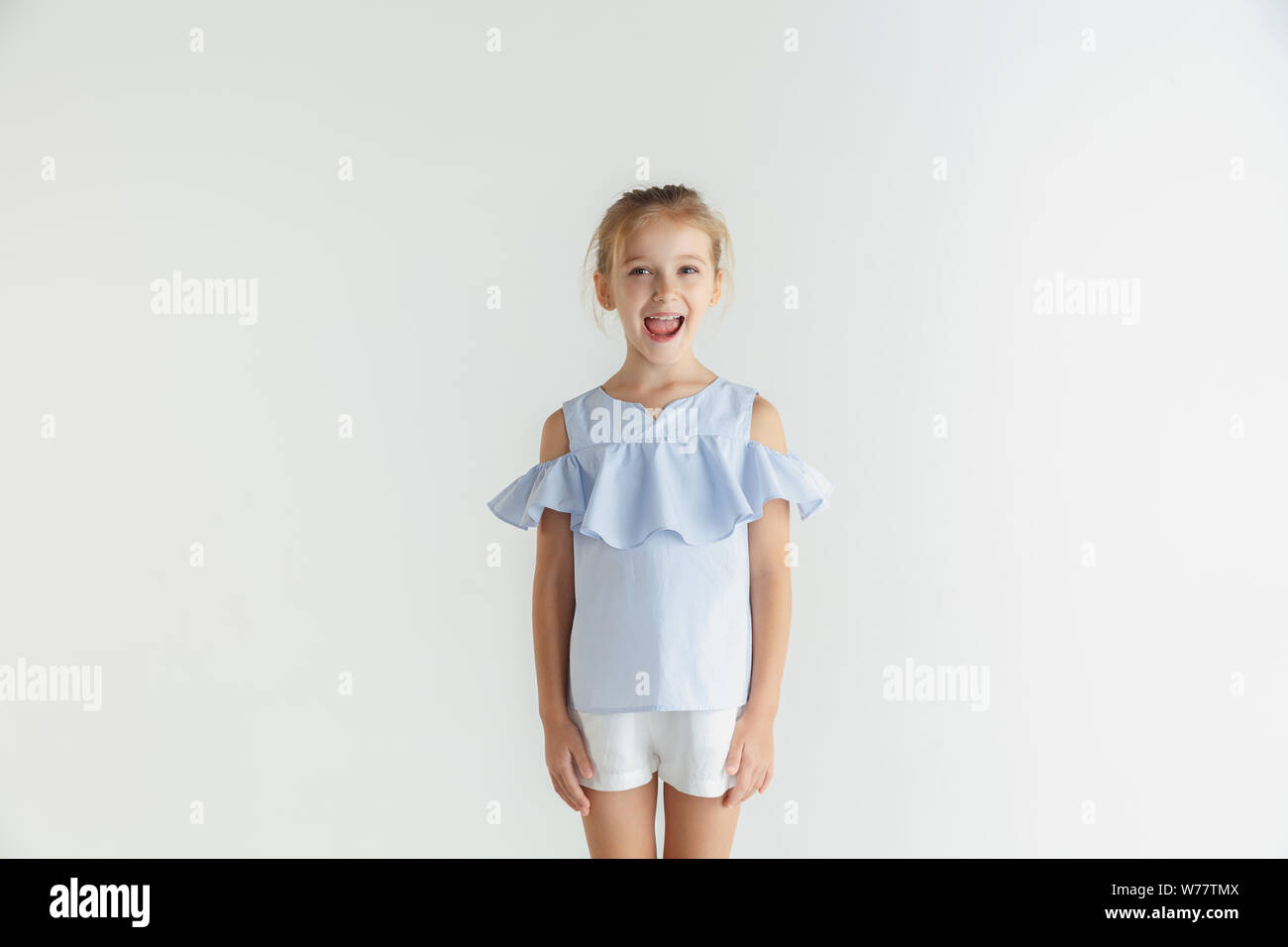 Stylish little smiling girl posing in casual clothes isolated on white ...