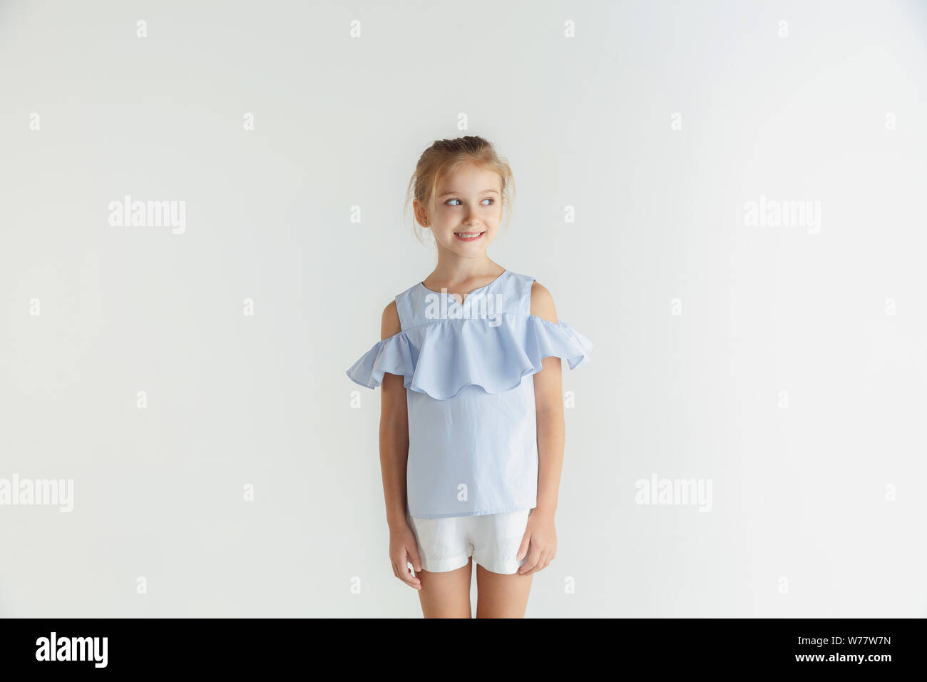 Stylish little smiling girl posing in casual clothes isolated on white ...