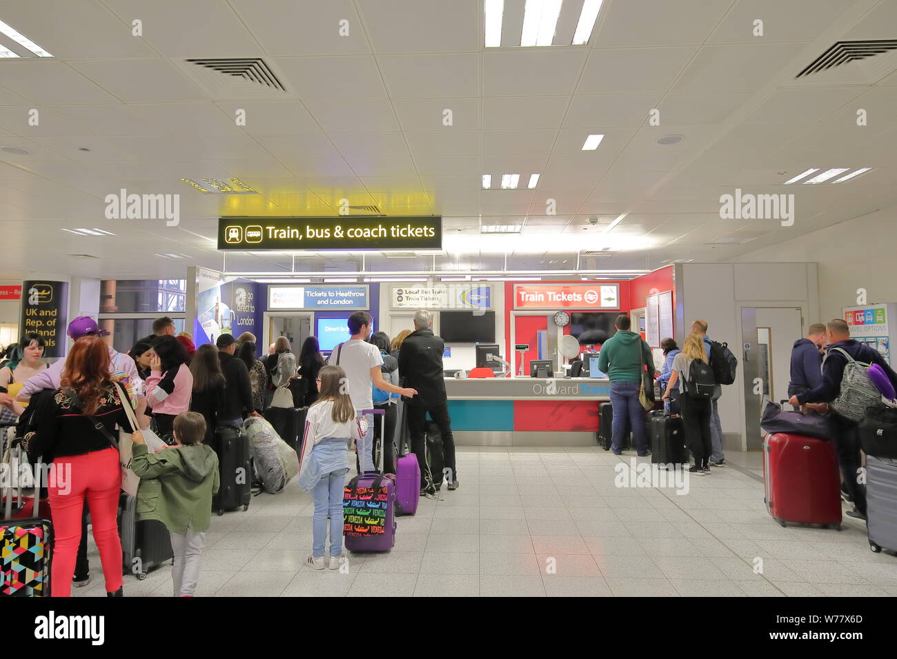 People queue to by ticket for bus and train at Gatwick airport London ...