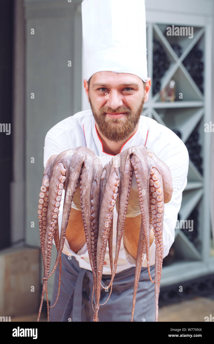 The chef is holding and cooks an octopus Stock Photo - Alamy