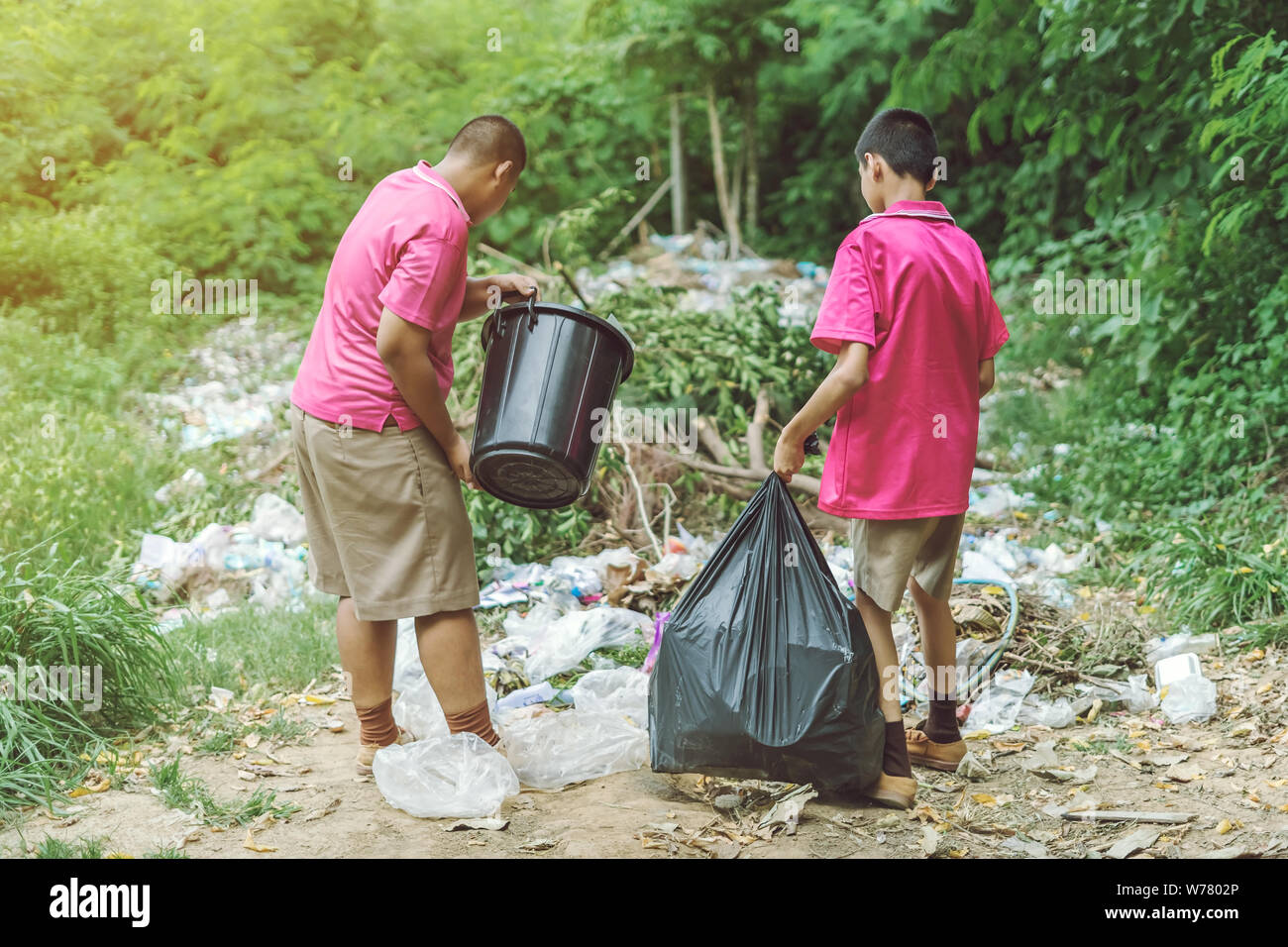 Male Students help to remove rubbish from the classroom to pile waste ...