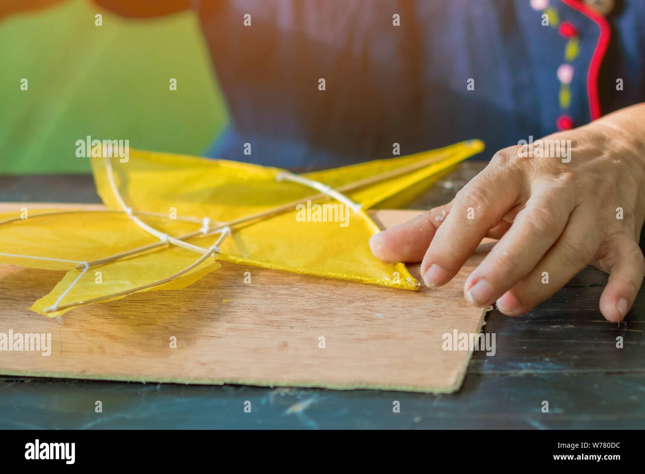 Eldery woman making and build star-shaped kite or thai name Chula kite ...