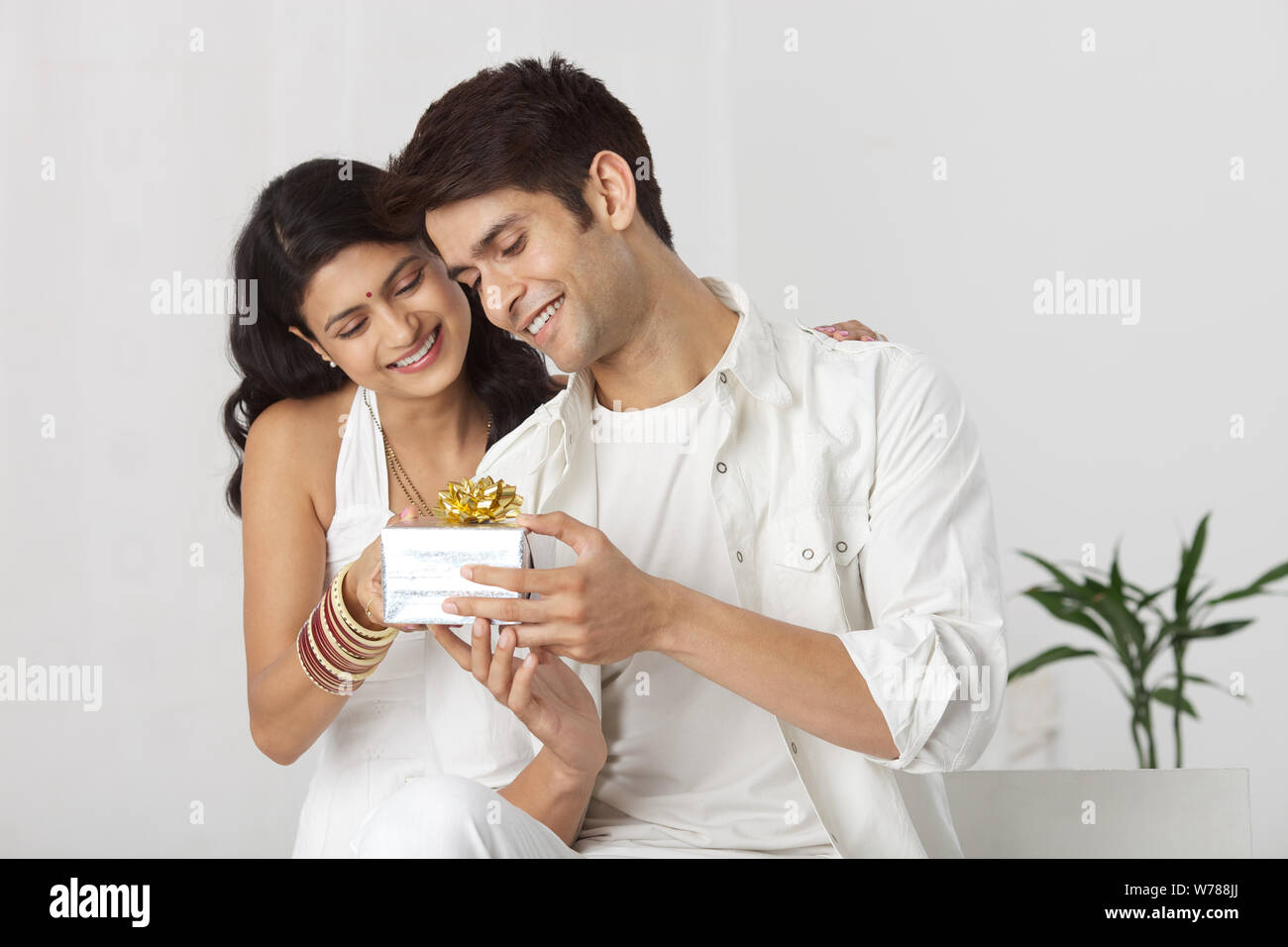 Young woman giving a gift to her husband Stock Photo - Alamy