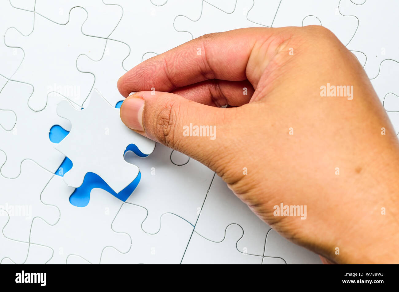 Person fitting the last puzzle piece.Concept image of building and button up Stock Photo - Alamy