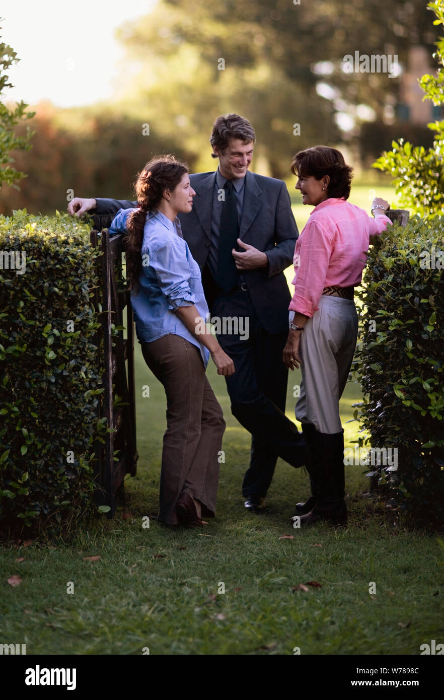 Three people are seen standing together at an entrance Stock Photo - Alamy