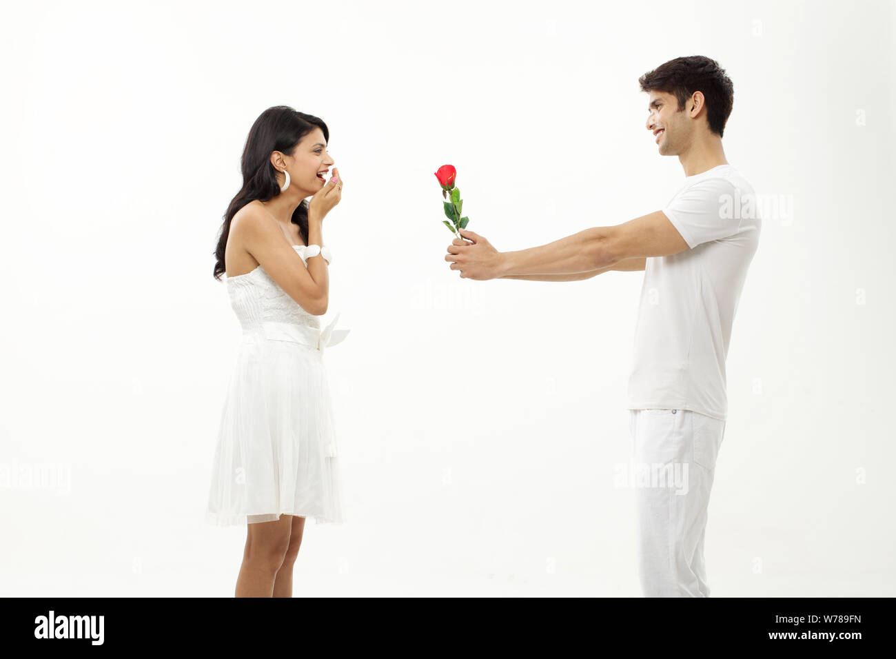 Man offering a rose to woman and smiling Stock Photo - Alamy