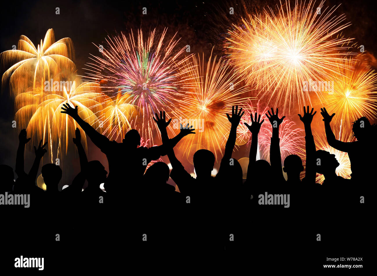 Group of people enjoying spectacular fireworks show in a carnival or ...