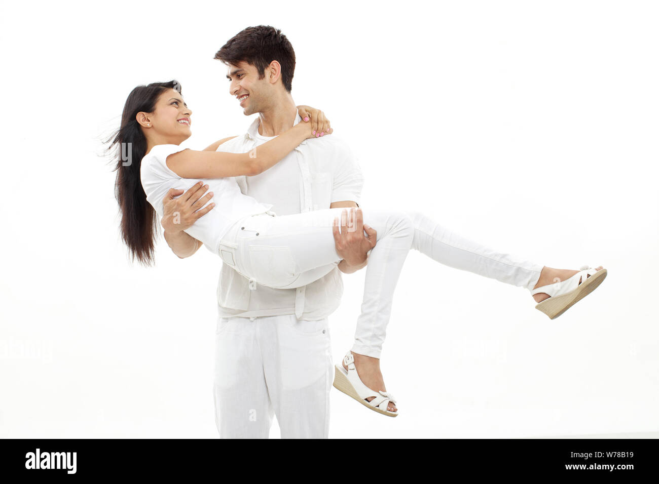 Young man carrying his girlfriend isolated on white background Stock ...