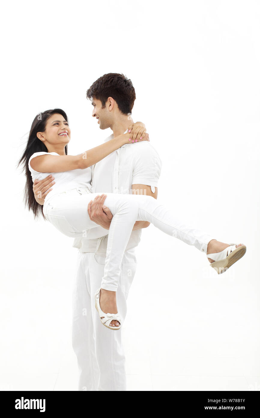 Young man carrying his girlfriend isolated on white background Stock ...