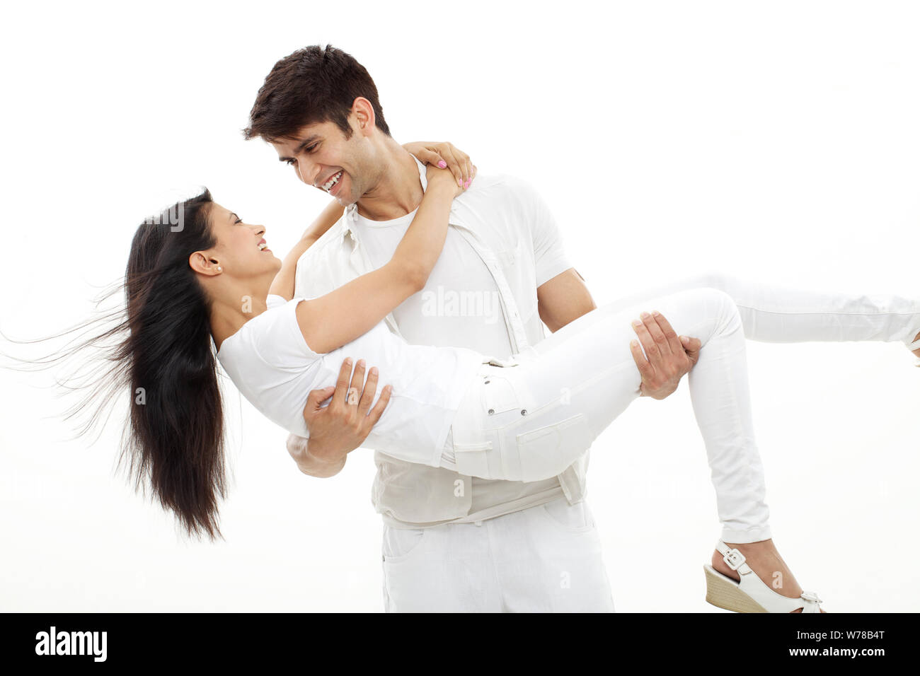 Young man carrying his girlfriend isolated on white background Stock ...