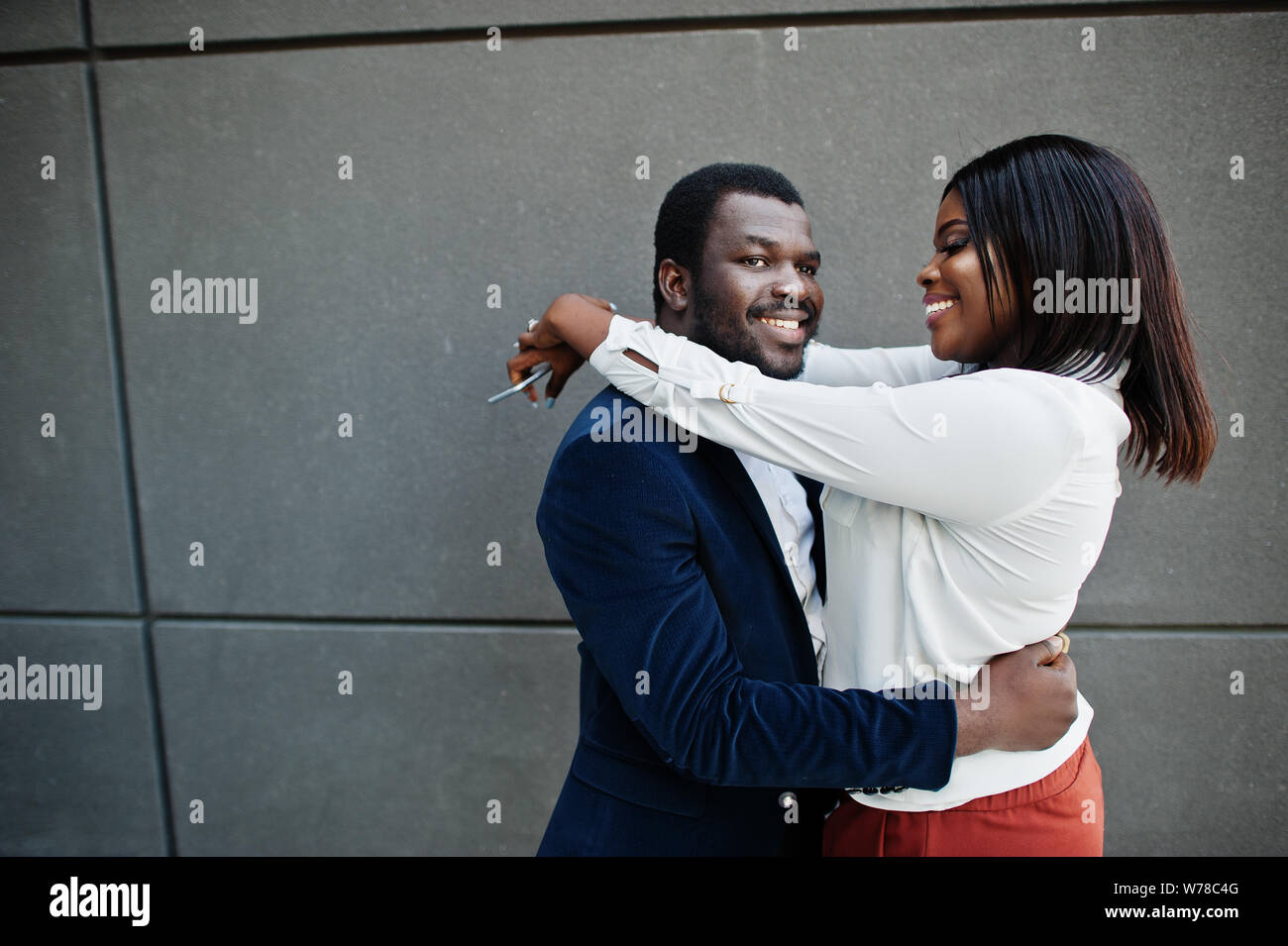 Stylish african american couple in formal wear hugs together. Romantic ...