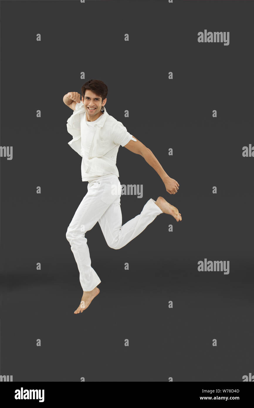 Young man jumping in mid air Stock Photo - Alamy