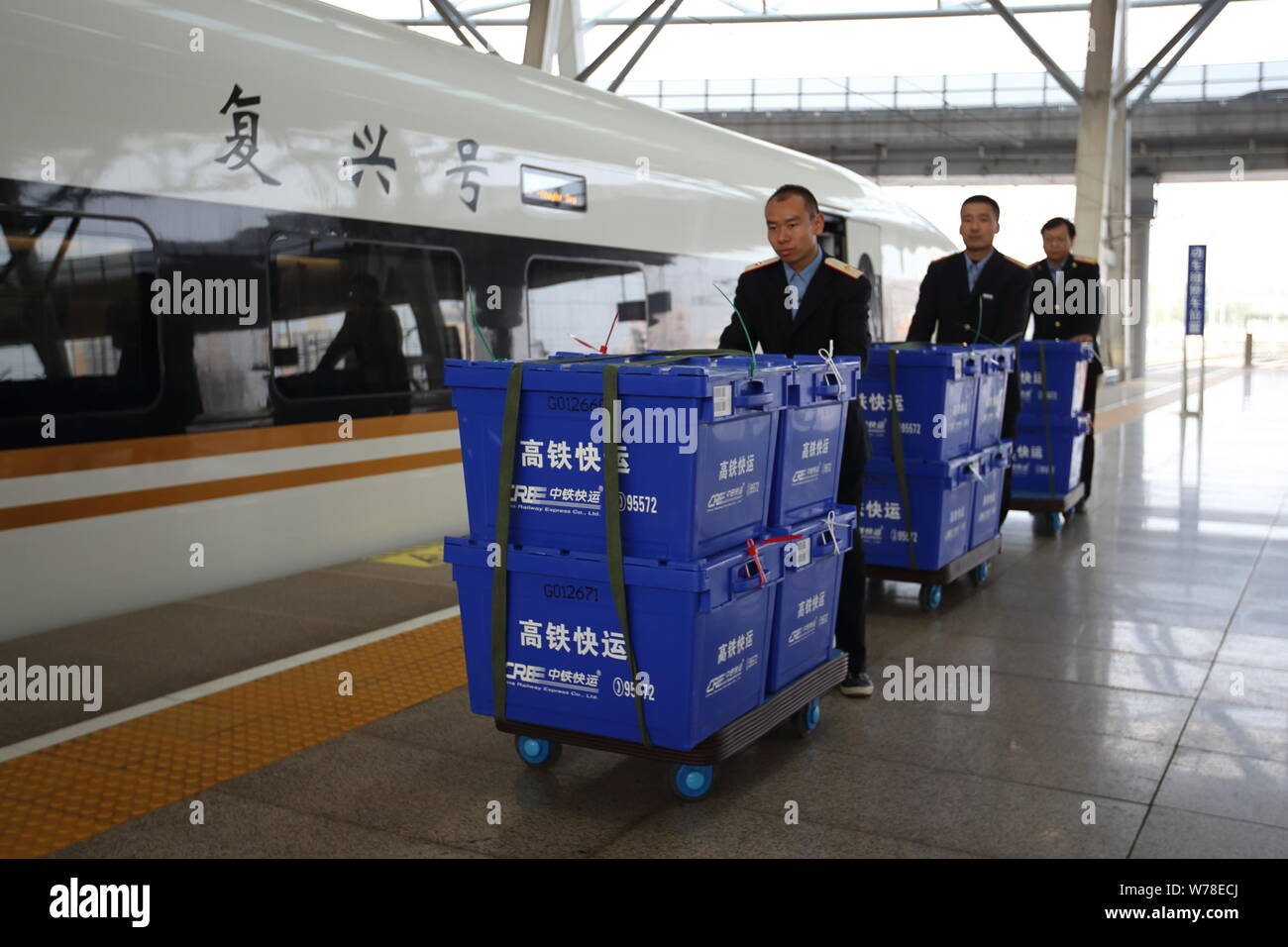 Chinese employees of CRE (China Railway Express) move the boxes with ...