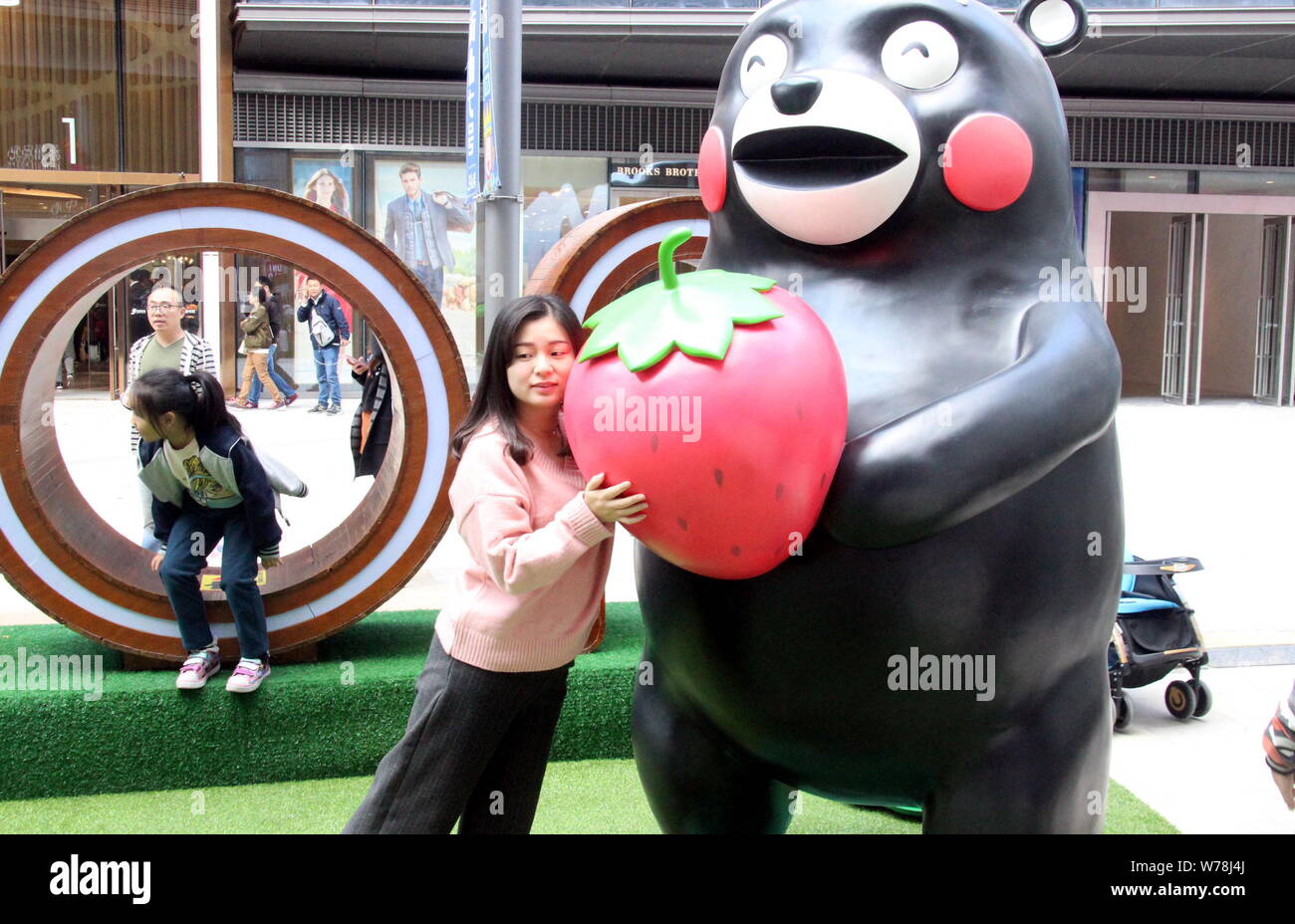 A visitor poses with a Kumamon sculpture for photos at the exhibition ...