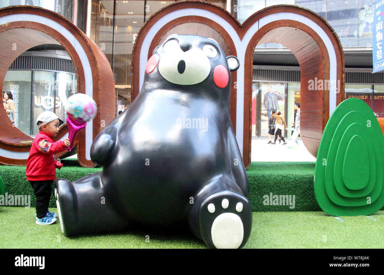 A child plays with a Kumamon sculpture at the exhibition of Japan's ...