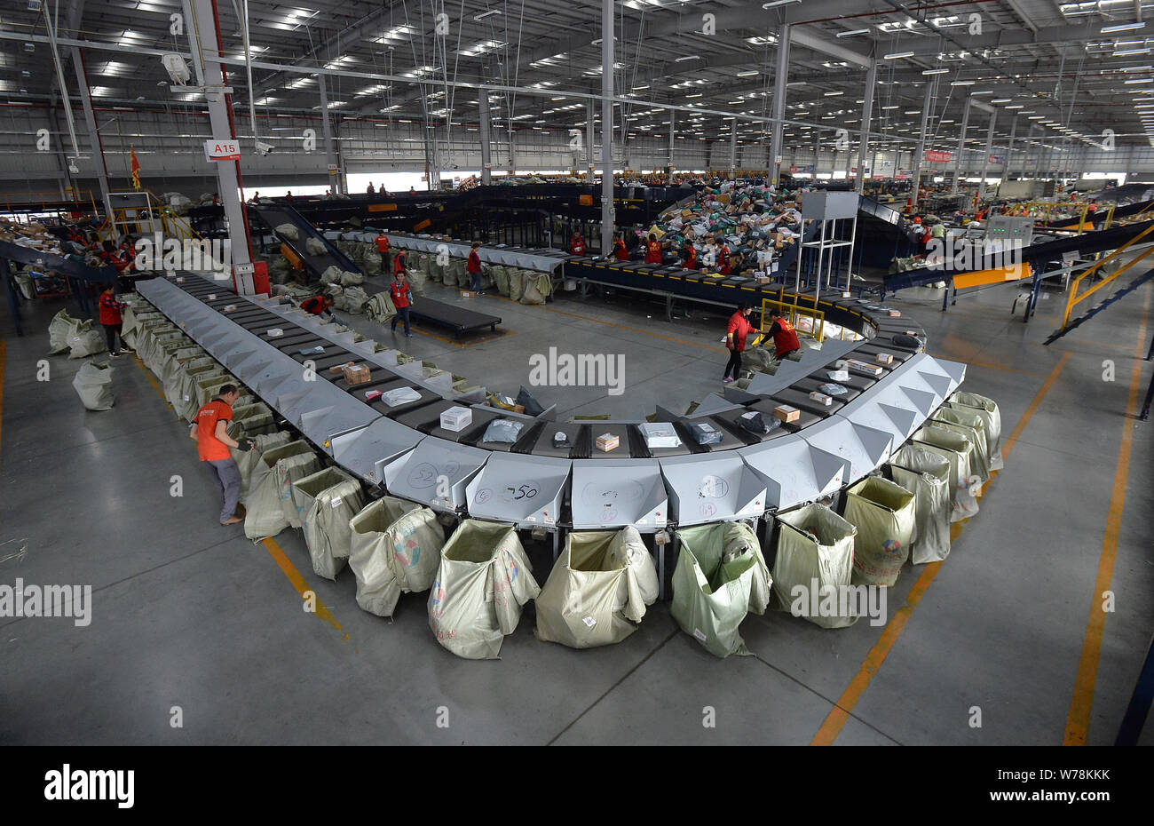 Chinese workers sort out piles of parcels, most of which are from ...