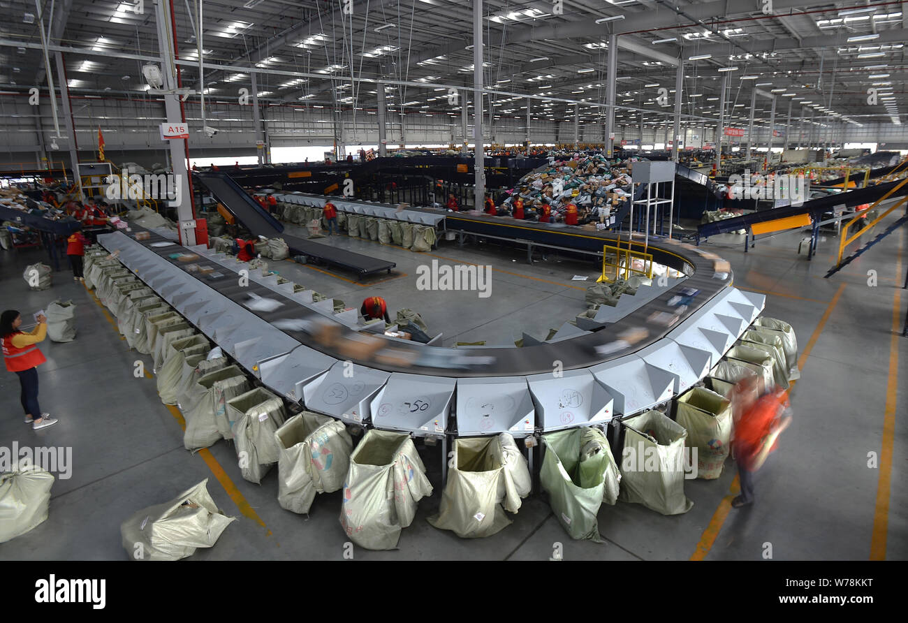 Chinese workers sort out piles of parcels, most of which are from ...