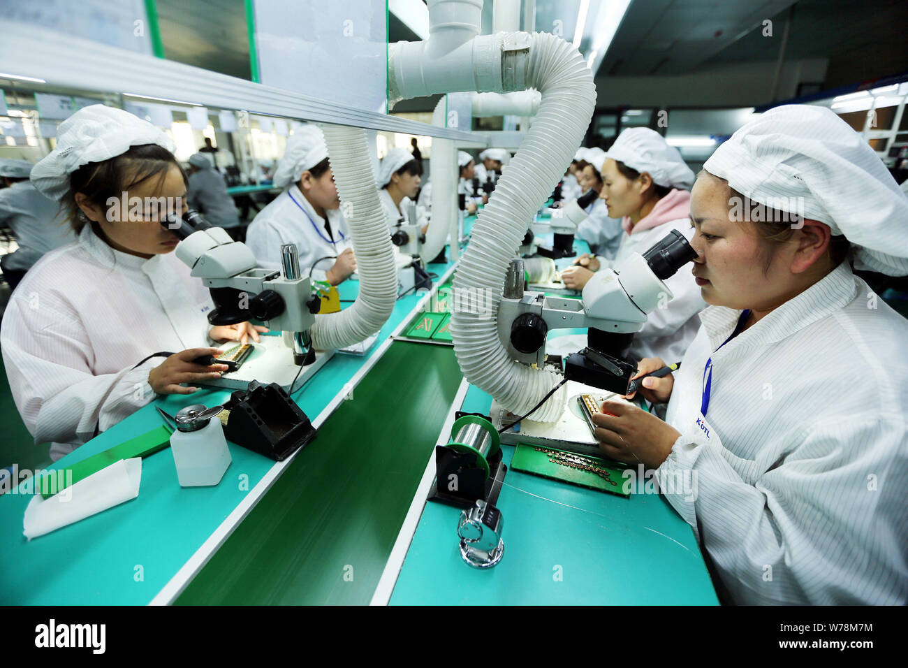 --FILE--Female Chinese workers produce mobile phone parts on the ...