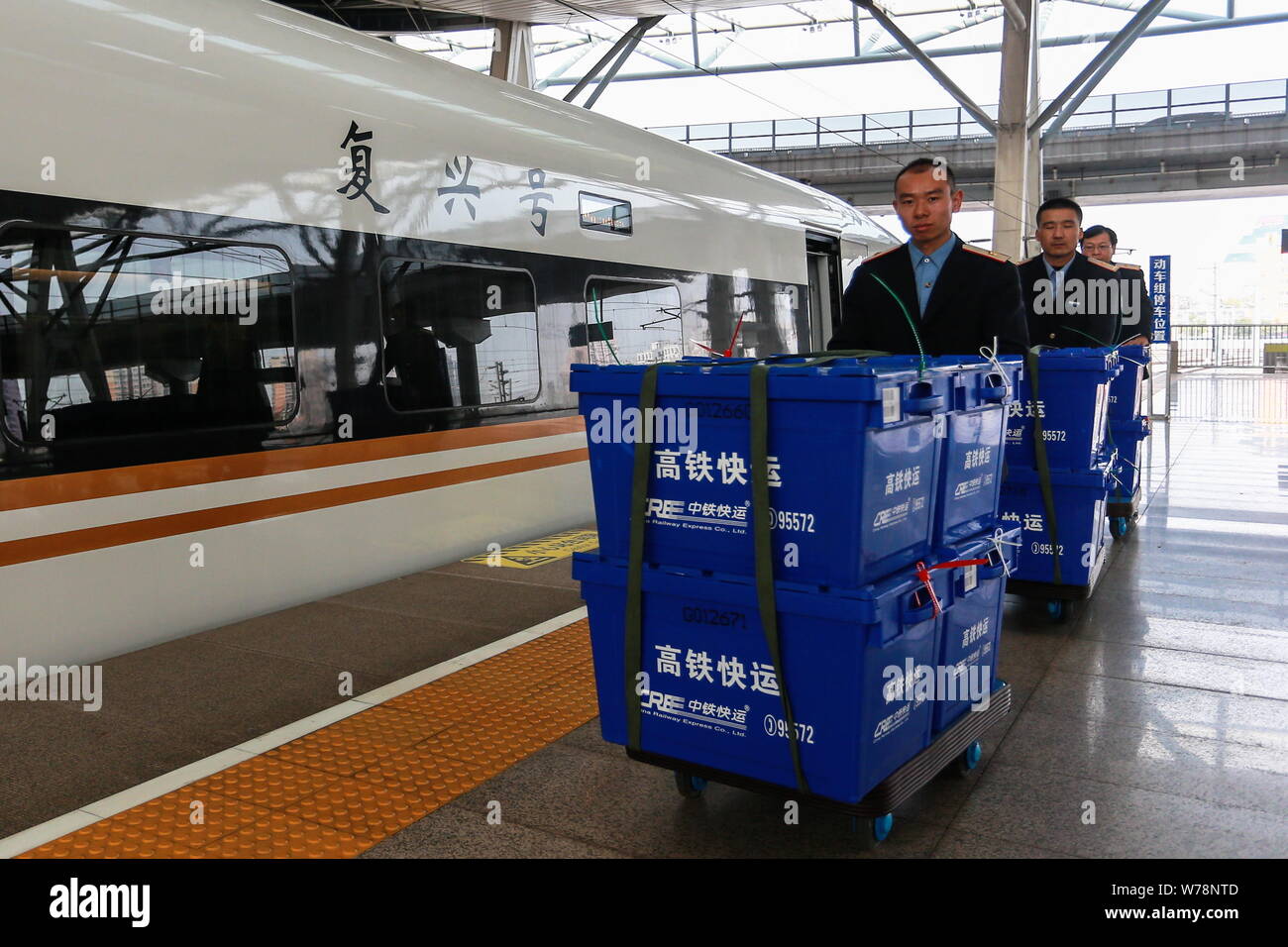 Chinese employees of CRE (China Railway Express) move the boxes with ...