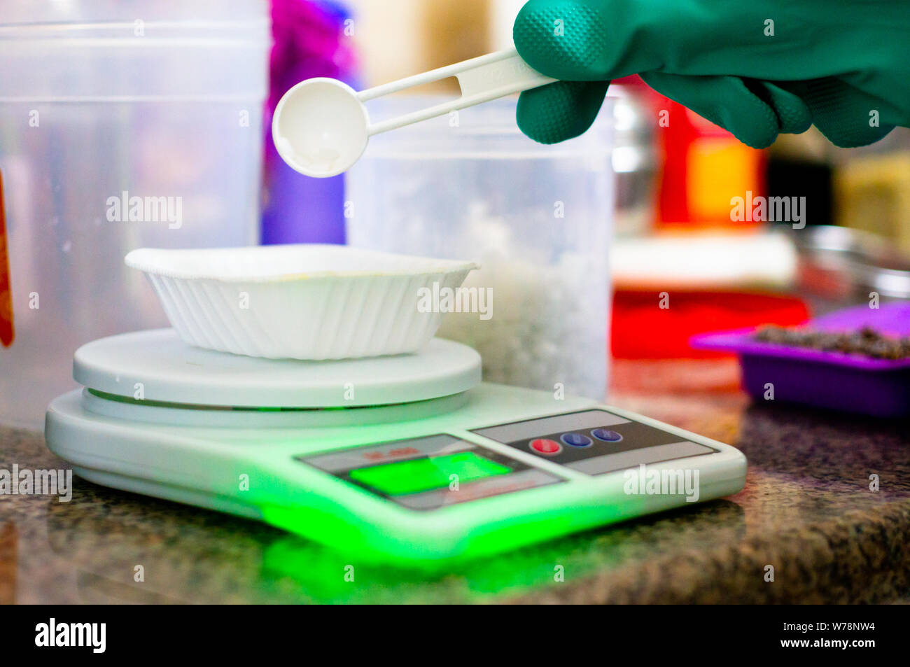 Lye caustic soda being measured out on weighing scale for making soap ...