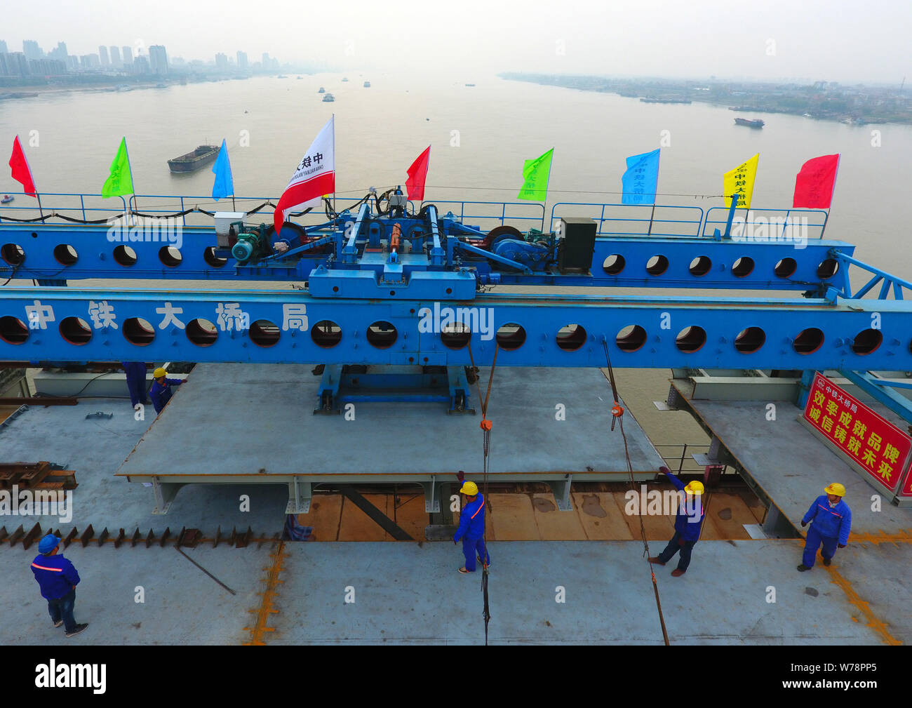 Chinese workers install the last steel bridge deck at the site of a ...